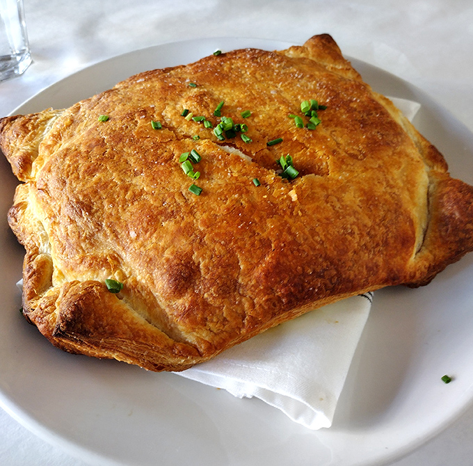 Whoever invented this golden-domed seafood pie deserves a Nobel Prize in comfort food. The flaky crust barely contains its treasures.