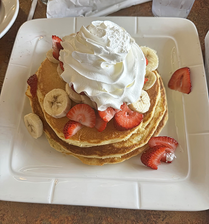 Pancake perfection that makes maple syrup feel like it finally found its soulmate. The fruit isn't decoration—it's essential supporting cast.
