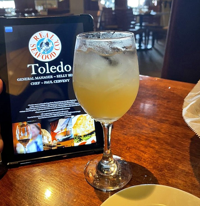 Golden peach sangria catching the light just right&mdash;proof that seafood isn't the only liquid treasure at this Toledo gem.