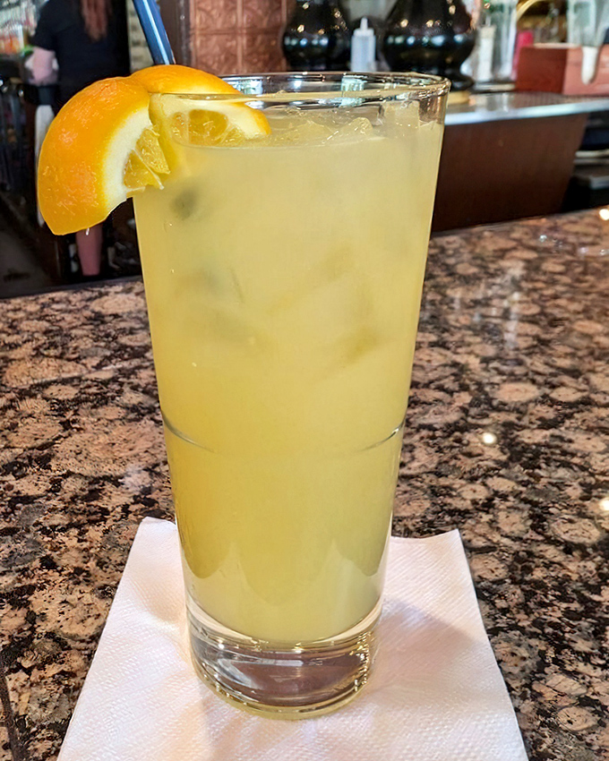 This isn't just a cocktail; it's liquid sunshine in a glass, garnished with orange and the promise of an afternoon well spent.