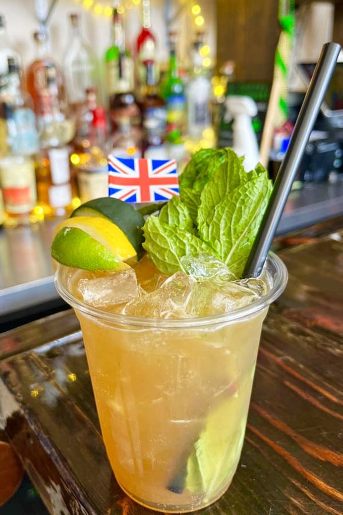 Their Pimm's Cup cocktail – a refreshing slice of British summer with mint, citrus, and a tiny Union Jack flag that says "Cheers, mate!"