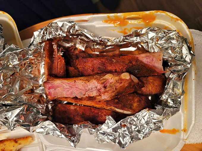 Ribs wrapped in foil like the precious gift they are. The smoke ring tells the story of hours spent becoming something greater than the sum of its parts.