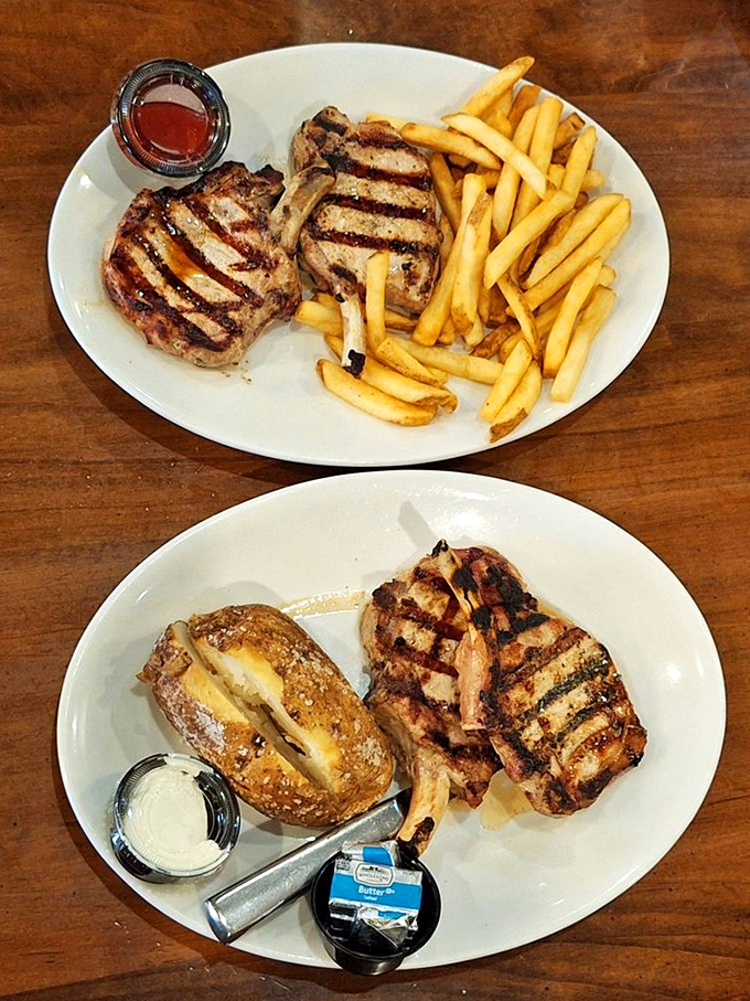 Two perfectly grilled pork chops with golden fries, and below, the baked potato that's dressed better than most people at the mall.