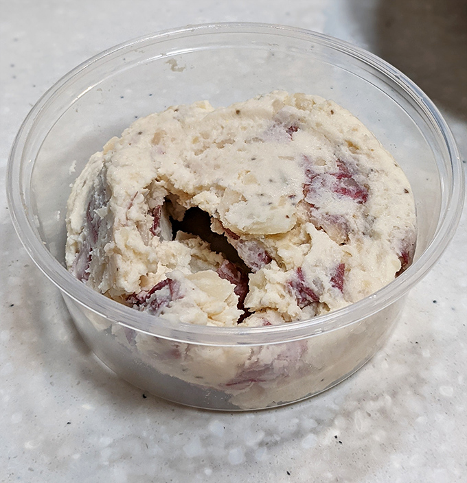 Potato salad that refuses to be a mere side dish. This creamy, red-flecked concoction demands equal billing with whatever sandwich it accompanies.