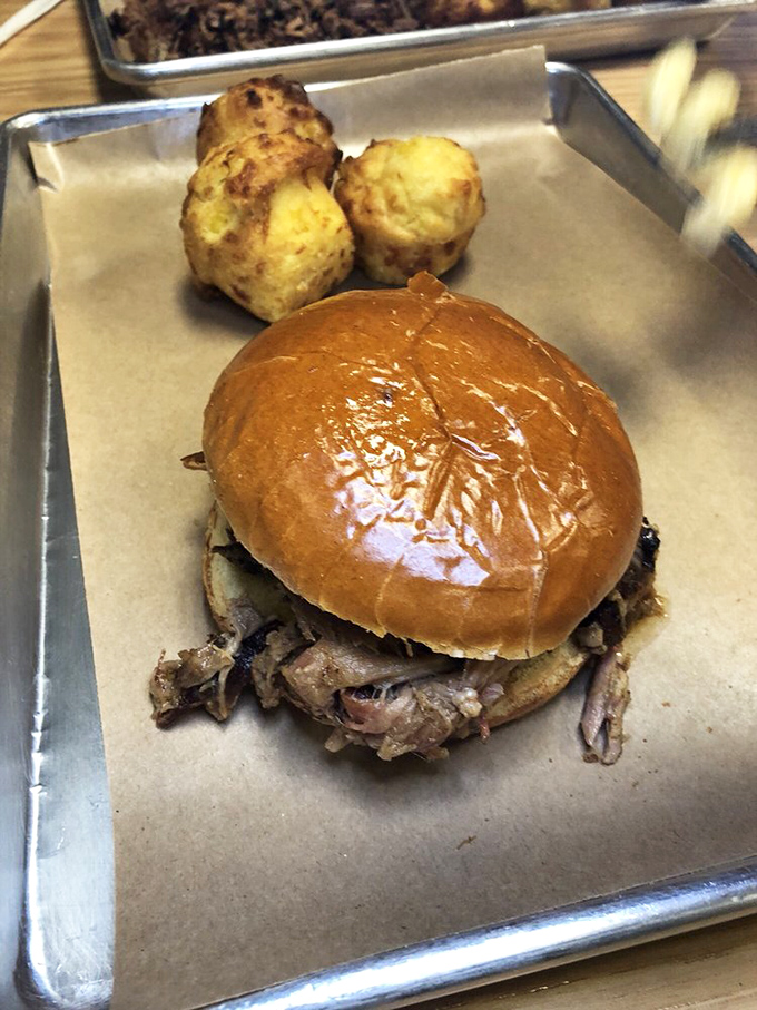 A pulled pork sandwich that understands its purpose in life: to deliver maximum flavor with minimal fuss. Those cornbread muffins aren't just sidekicks.