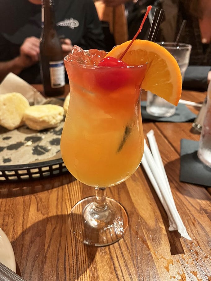 This cocktail, garnished with orange and cherry, promises to transport you to a happier place with just one sip.