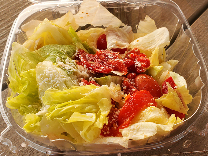 Even the salad looks like it's having more fun here – crisp lettuce, vibrant tomatoes, and roasted peppers that didn't come from some sad pre-packaged bag.