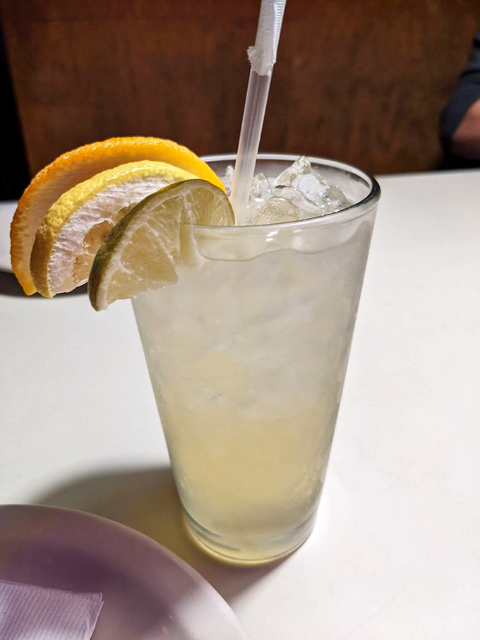 A refreshing citrus-garnished drink that doesn't just quench thirst—it provides the perfect palate reset between bites of pizza perfection.