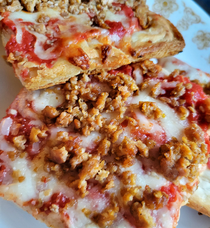 Sausage pizza done right &ndash; where each bite delivers that perfect marriage of spicy meat, tangy sauce, and cheese that stretches for days.