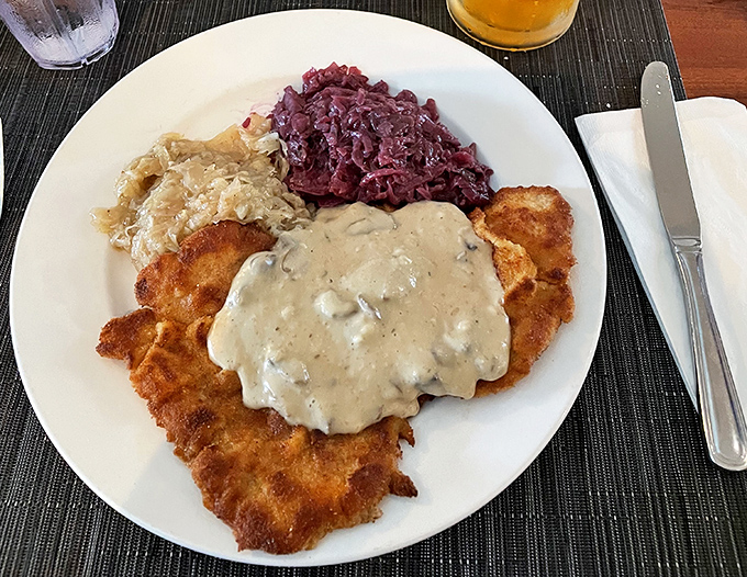 Golden-fried schnitzel swimming in mushroom sauce with red cabbage standing by. This plate has more German heritage than my DNA test.