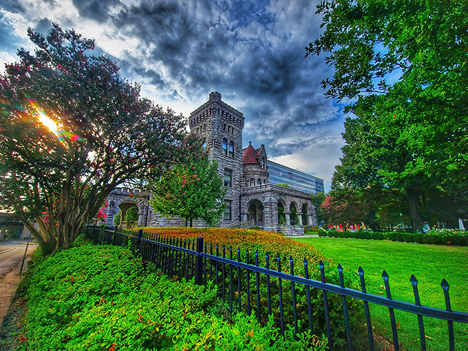 Flowering trees and wrought iron fencing create a picturesque frame for this stone beauty. The contrast between castle and modern skyline is delightfully jarring.