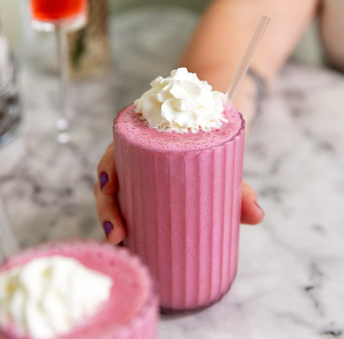 This pink smoothie isn't just a drink&mdash;it's a portable happiness machine topped with a cloud of whipped cream.