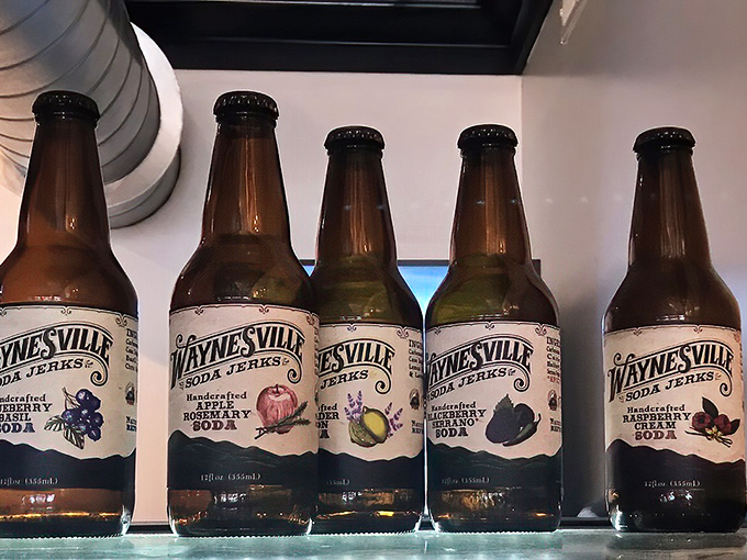 Waynesville Soda Jerks' artisanal bottles line up like colorful soldiers, ready to rescue you from ordinary beverage experiences with flavors like blueberry and apple rosemary.