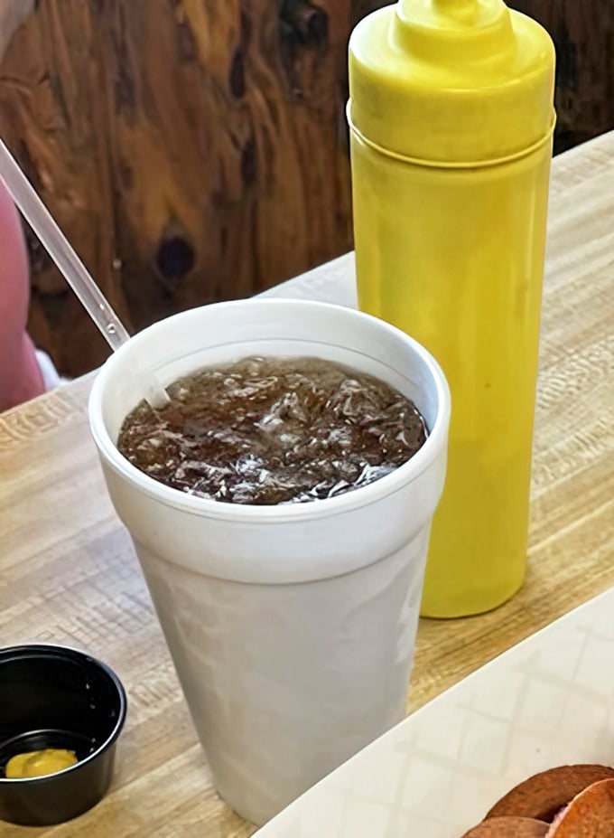 Nothing fancy here—just a classic soda in a foam cup with that yellow mustard bottle standing by. Sometimes the simplest pleasures are the best.