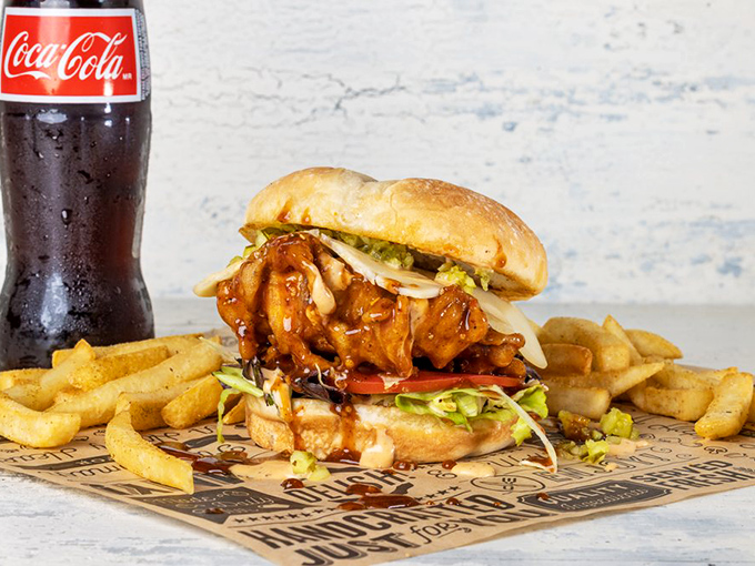 This isn't just a sandwich; it's architecture. Crispy chicken, fresh veggies, and sauce that'll make you forget your table manners.