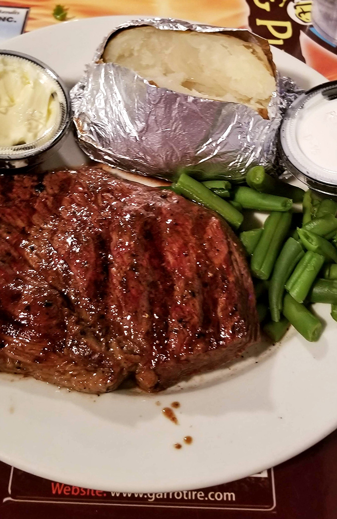 Steak night done right. This perfectly grilled beauty shares the plate with a foil-wrapped potato that's practically begging to be unwrapped.
