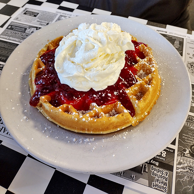 A Belgian waffle crowned with strawberries and whipped cream &ndash; dessert masquerading as breakfast, and nobody's complaining.