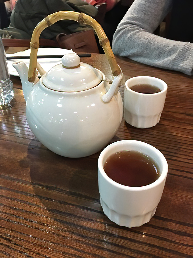 The elegant simplicity of Chinese tea service: bamboo-handled pot, small cups, and the promise of leaves unfurling in hot water like a slow-motion ballet.