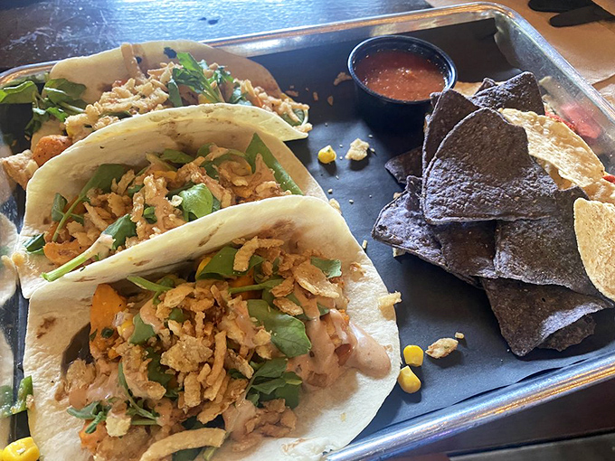 Tacos that refuse to be typecast. These tortilla-wrapped treasures showcase Yellow Dog's versatility beyond traditional BBQ, with crispy toppings adding textural symphony to each bite.
