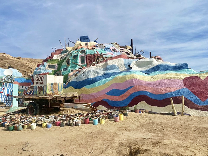 Paint buckets await their turn to become part of the ever-evolving masterpiece, each gallon representing another layer in this monument to devotion.
