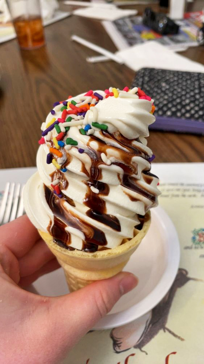 Soft-serve ice cream dressed for success with chocolate drizzle and rainbow sprinkles&mdash;proof that happiness can indeed be purchased for under $3.