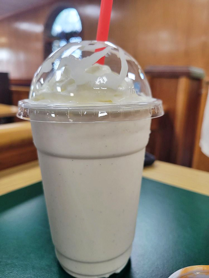 A vanilla shake so thick it defies gravity. The straw stands at attention, as if saluting its own delicious destiny.
