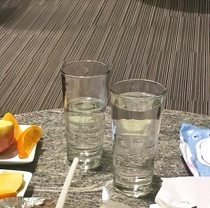 Two glasses of water stand ready for the inevitable: that moment when your taste buds need a brief intermission from flavor overload.