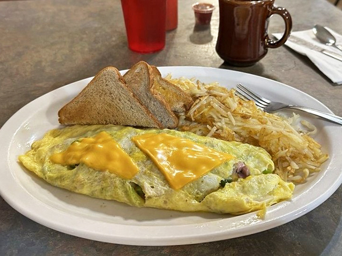 Breakfast of champions – a Western omelet that's seen more sunrises than most roosters, with crispy hash browns that crackle with each forkful.