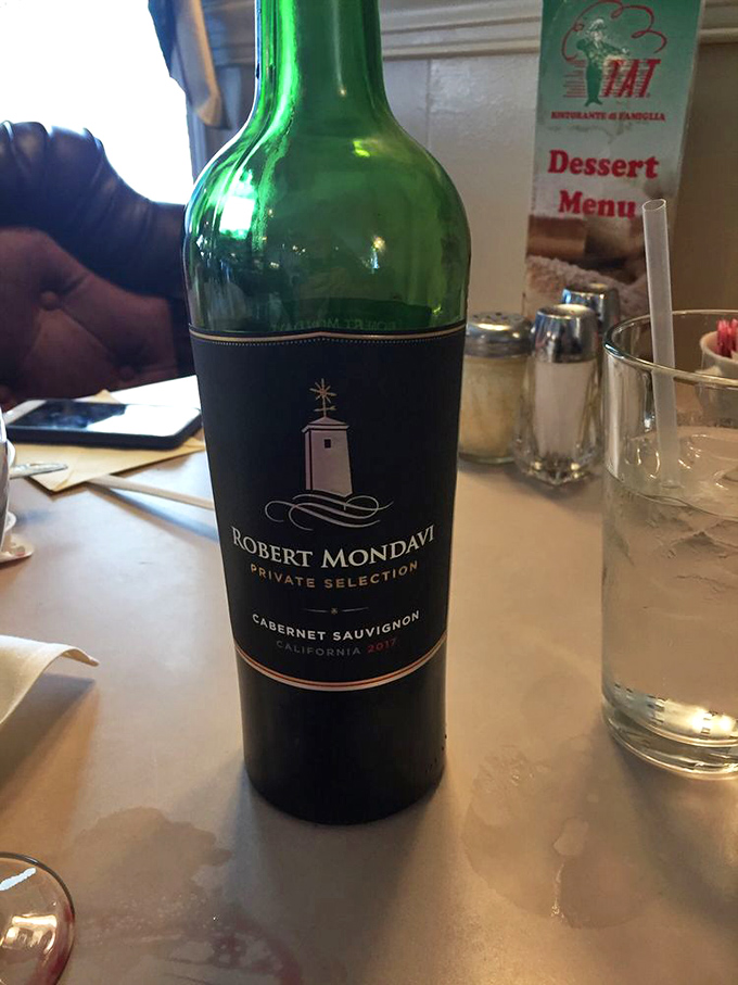 A bottle of Robert Mondavi stands ready for duty—because good Italian food deserves good wine, like Sinatra deserves a microphone.