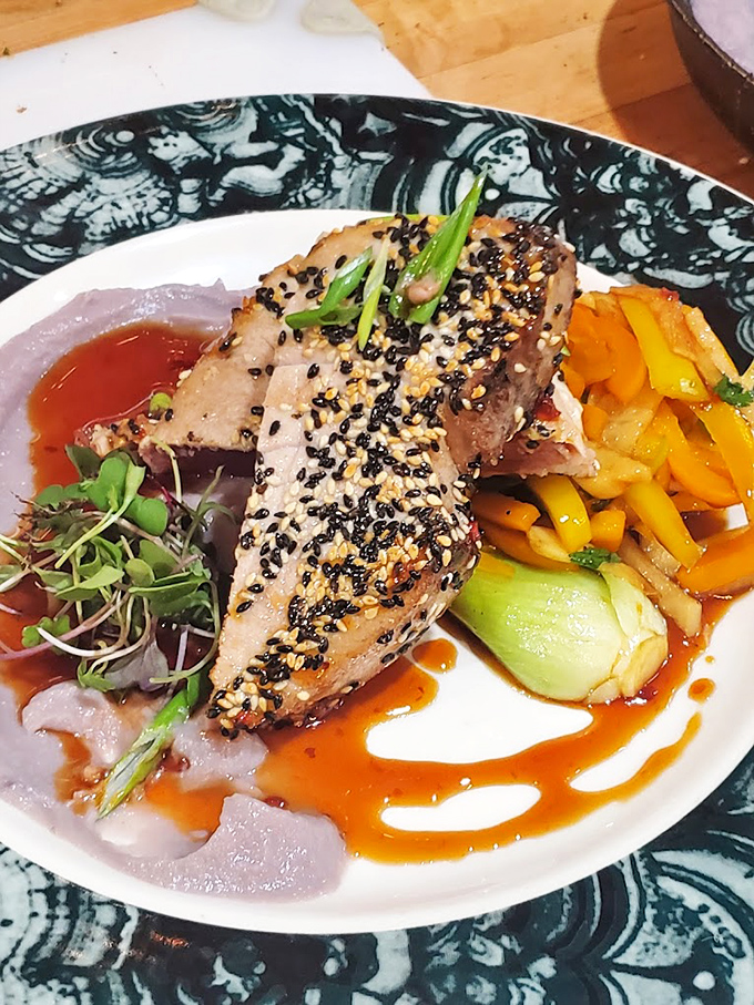 Ahi tuna dressed for success with black sesame confetti and a colorful entourage of vegetables. Ocean-to-plate perfection.