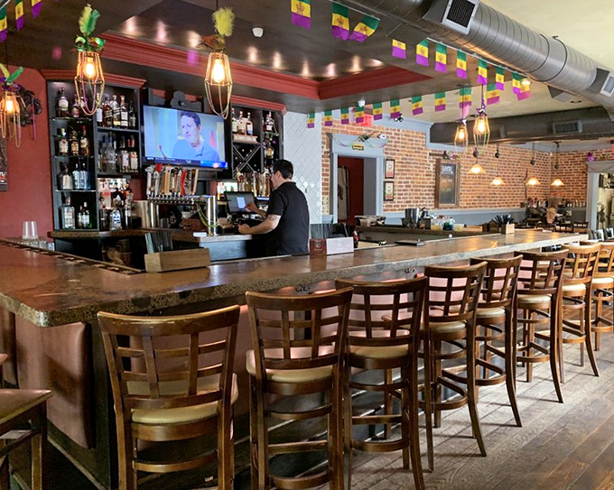 The bar area strikes that perfect balance between "I'm a serious cocktail establishment" and "we're all friends here." Those colorful flags promise a good time.