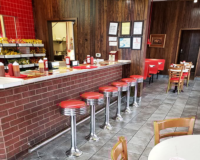Classic diner counter seating where barbecue dreams come true. Those red stools aren't just places to sit&mdash;they're front-row seats to culinary theater.