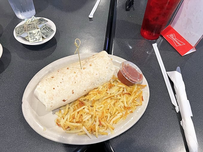 The breakfast burrito: where morning ingredients gather for a meeting wrapped in a warm tortilla blanket, with crispy hash browns standing guard. 