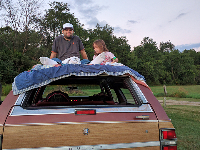 The ultimate drive-in hack: a classic station wagon becomes the perfect viewing perch with blankets, pillows, and the best seat in the house.