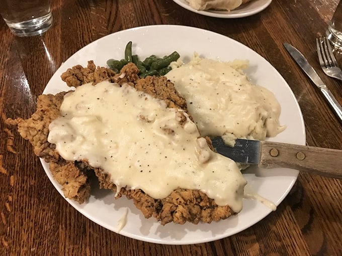 Country-fried steak swimming in peppery gravy alongside cloud-like mashed potatoes – comfort food that hugs you from the inside out.