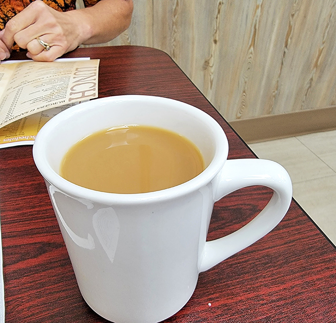 Coffee in a classic white mug&mdash;no pretentious pour-overs or fancy foam art, just honest caffeine that says "good morning" like an old friend.