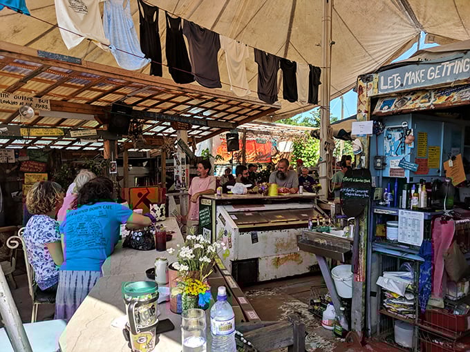 Where strangers become friends over drinks. The makeshift bar area transforms into a community gathering spot under the watchful eye of handwritten wisdom.