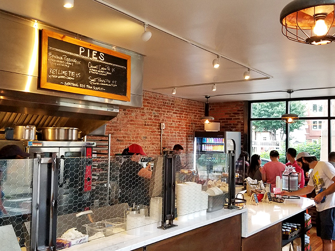 The open kitchen concept lets you witness the magic happening while industrial lighting creates serious foodie atmosphere vibes.