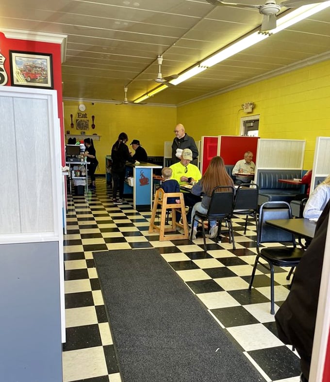 The checkered floor and sunny yellow walls create that perfect small-town diner atmosphere where strangers become friends over coffee and conversation.