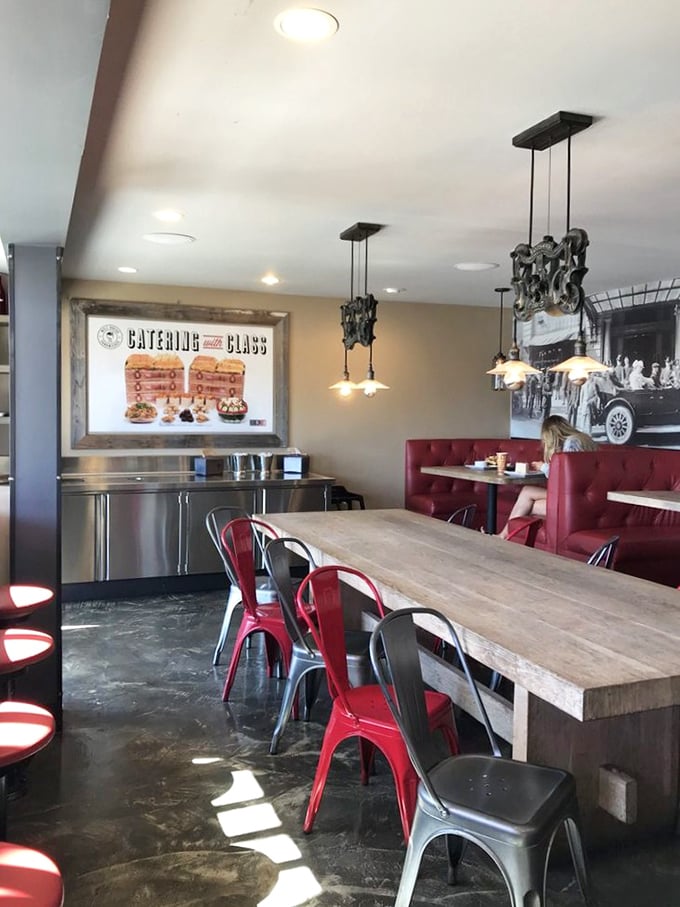 Red chairs pop against wooden tables like exclamation points in a delicious conversation. Comfort designed for serious sandwich business.