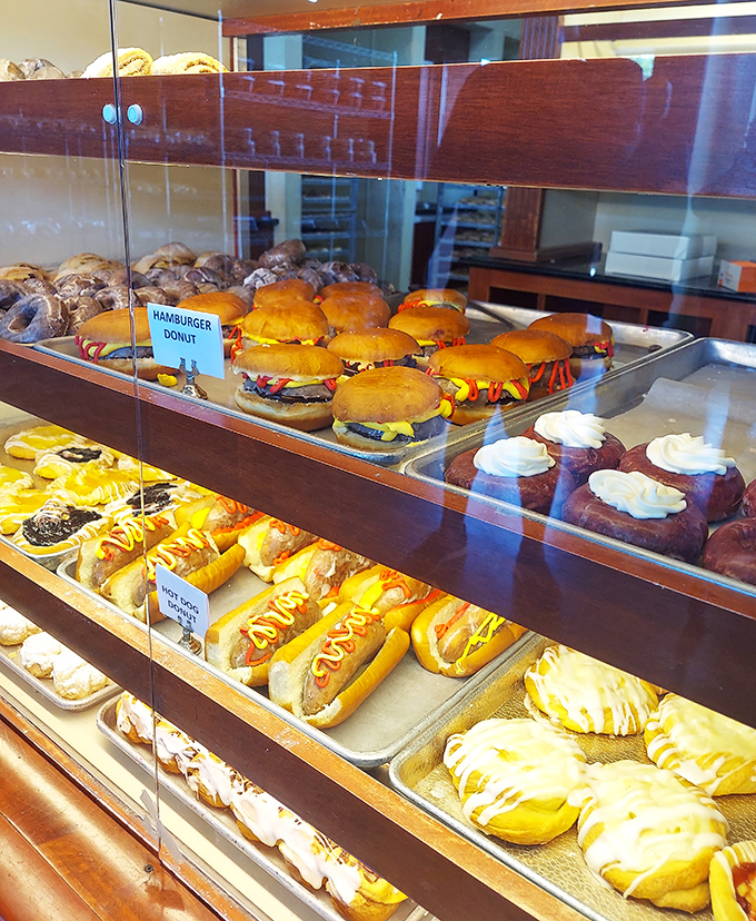 The display case &ndash; where hamburger donuts and cream-filled long johns compete for your attention in the most delicious standoff in town.