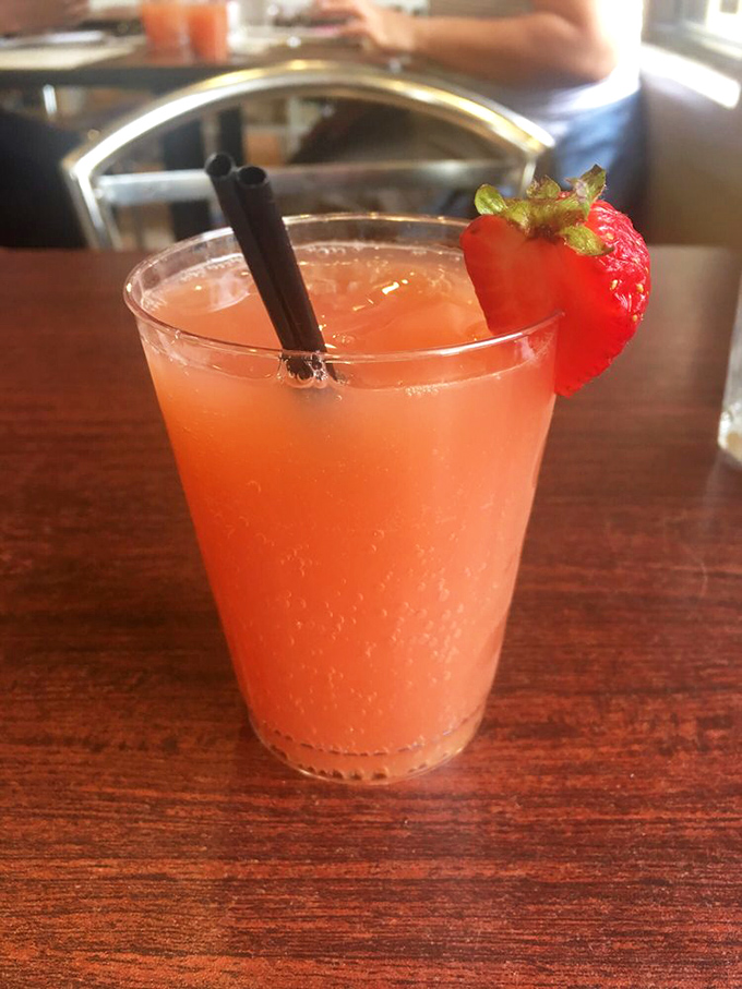 A cocktail that looks like sunrise in a glass. That strawberry garnish isn't just pretty, it's promising you this drink tastes like summer vacation feels.