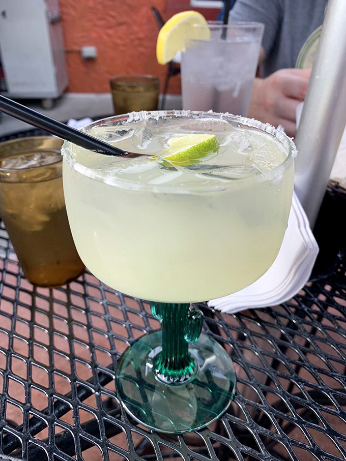 A margarita that's dressed for success with its salt rim and lime wedge. This isn't just a drink; it's vacation in a glass.