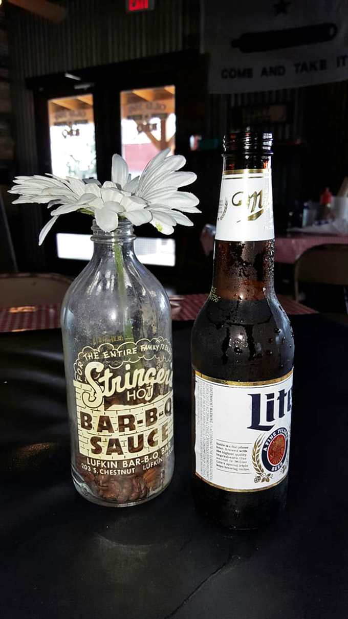Every proper Texas meal deserves proper hydration&mdash;a repurposed sauce bottle becomes a flower vase while a cold beer stands at attention.