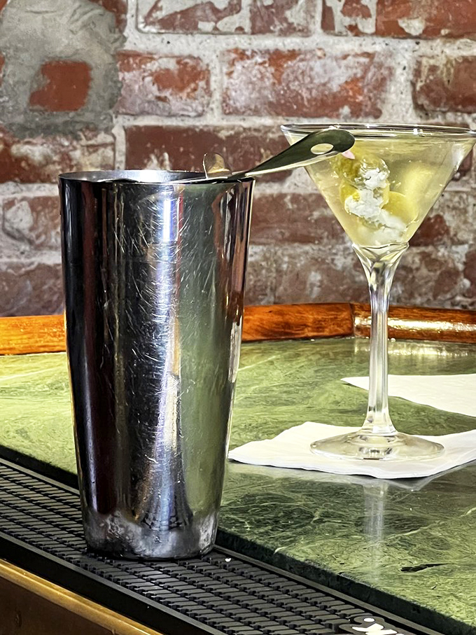 The martini sits elegantly against exposed brick&mdash;a timeless pairing that says "your day is officially over, and the good part has begun."