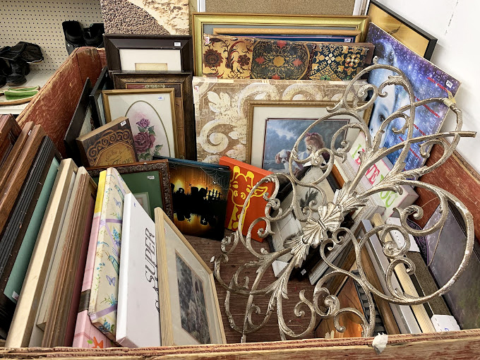 This treasure trove of frames and wall art resembles an archaeological dig into America's living room history, metal scrollwork included.