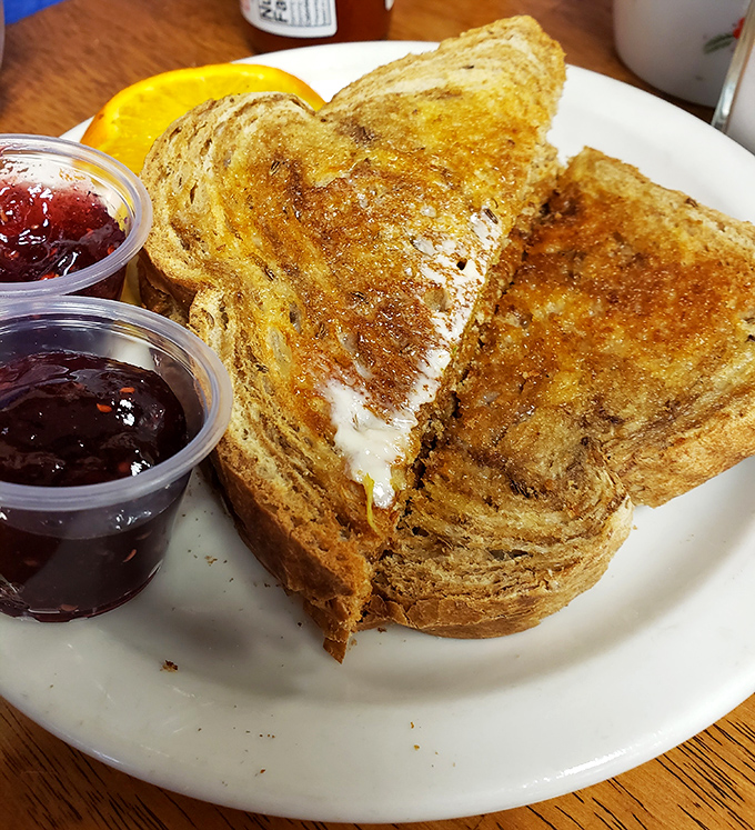 This French toast looks like it's been dipped in custard, kissed by butter, and sent straight from breakfast heaven with jam that's definitely not from a plastic packet.