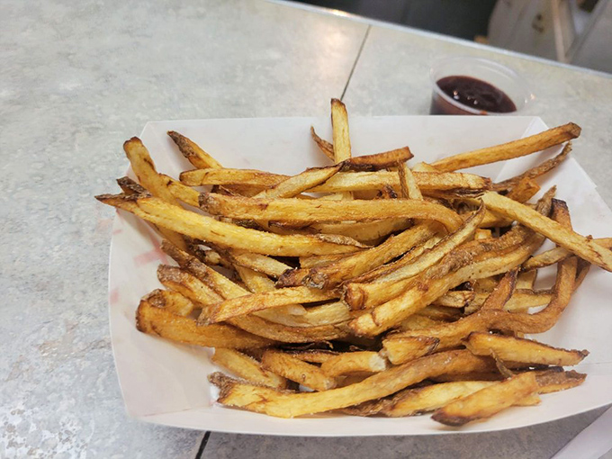 These aren't those wimpy, uniform frozen fries. These hand-cut beauties have personality, crispiness, and enough salt to make your cardiologist wince and your taste buds sing.