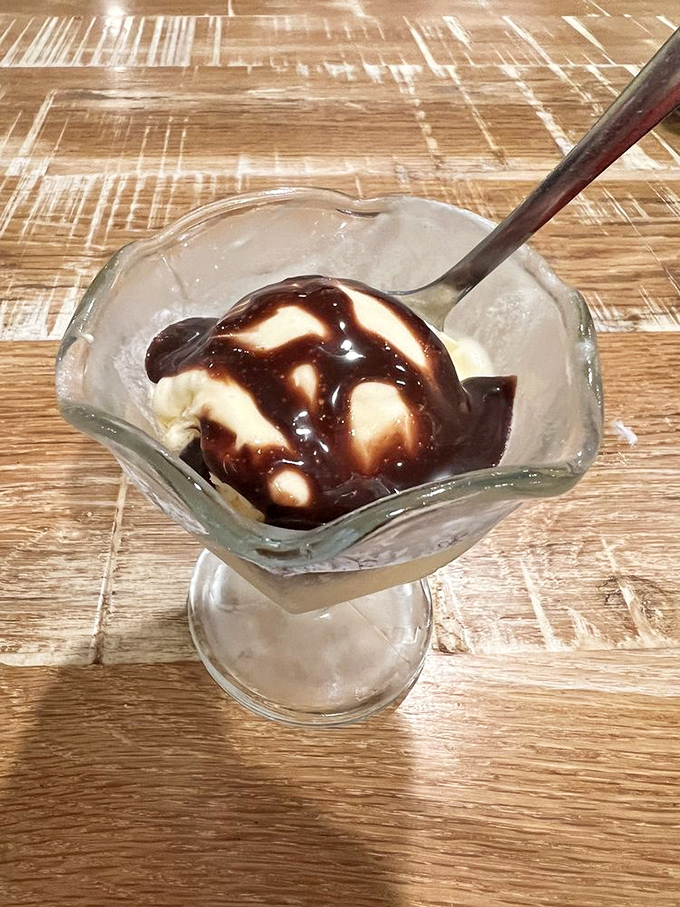 A simple scoop of vanilla ice cream drizzled with chocolate sauce&mdash;dessert minimalism that somehow manages to hit all the right notes.