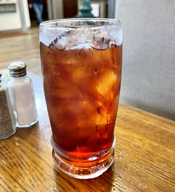 An ice-cold sweet tea waiting patiently beside salt and pepper shakers&mdash;the unsung hero that helps you pace yourself through multiple buffet rounds.